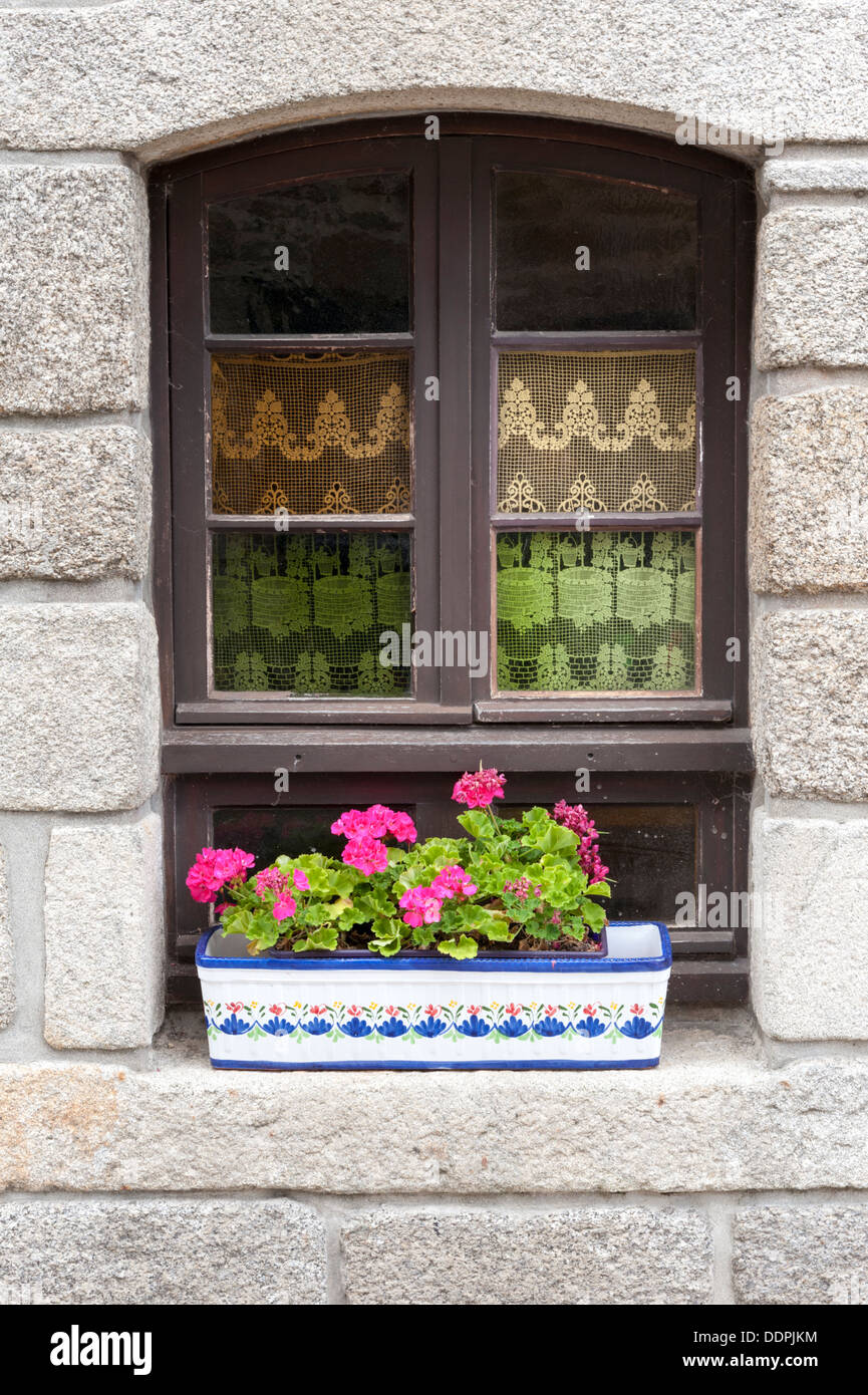 Pretty window in a building in Brittany France with flowers in window ...