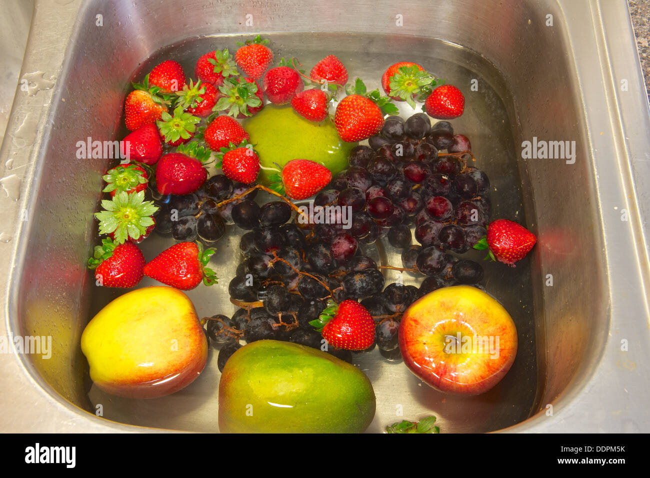 Fruit being washed in kitchen sink Stock Photo - Alamy