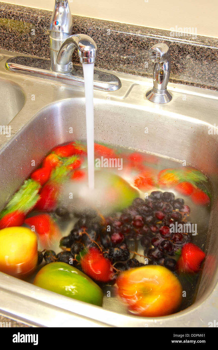 Fruit being washed in kitchen sink Stock Photo - Alamy