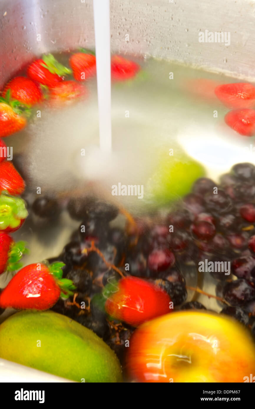 Fruit being washed in kitchen sink Stock Photo - Alamy