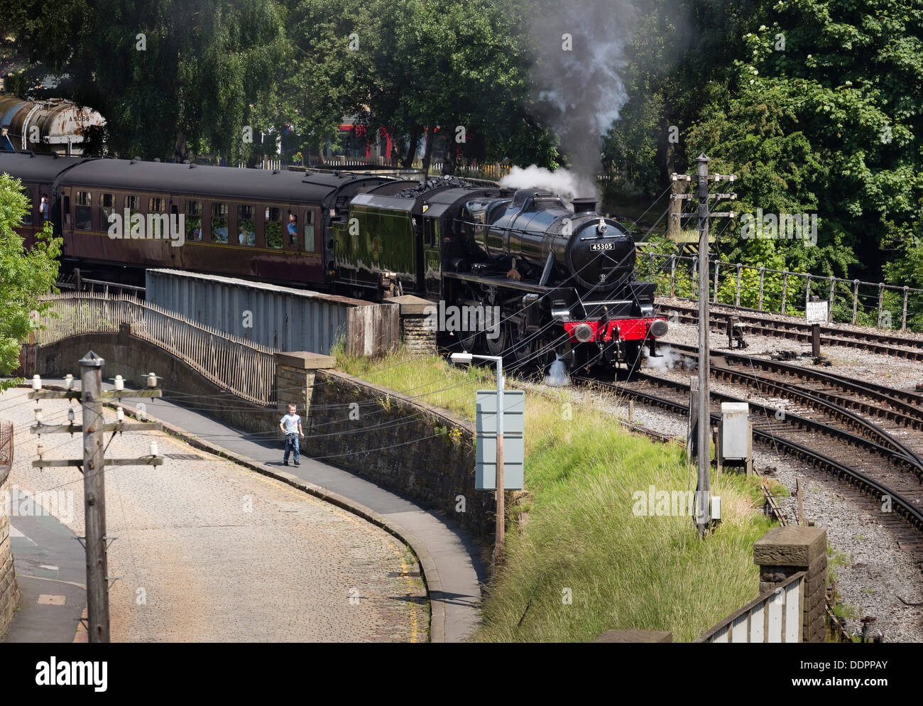 A boy racing a steam train as it pulls out of Keighley Station, on the ...
