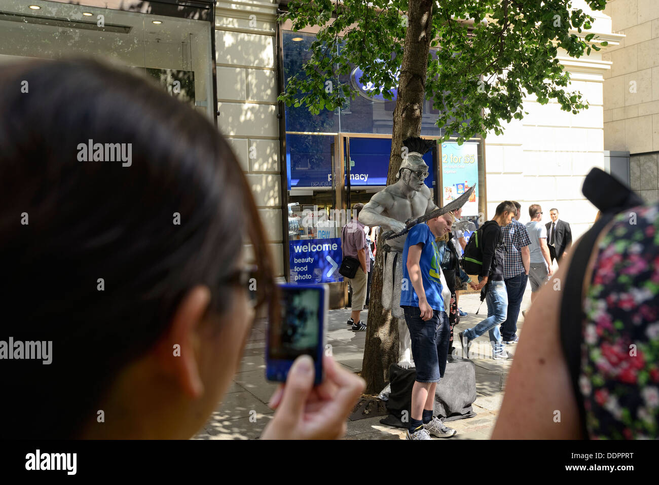 Street artist performing in front of a crowd of tourists in London ...