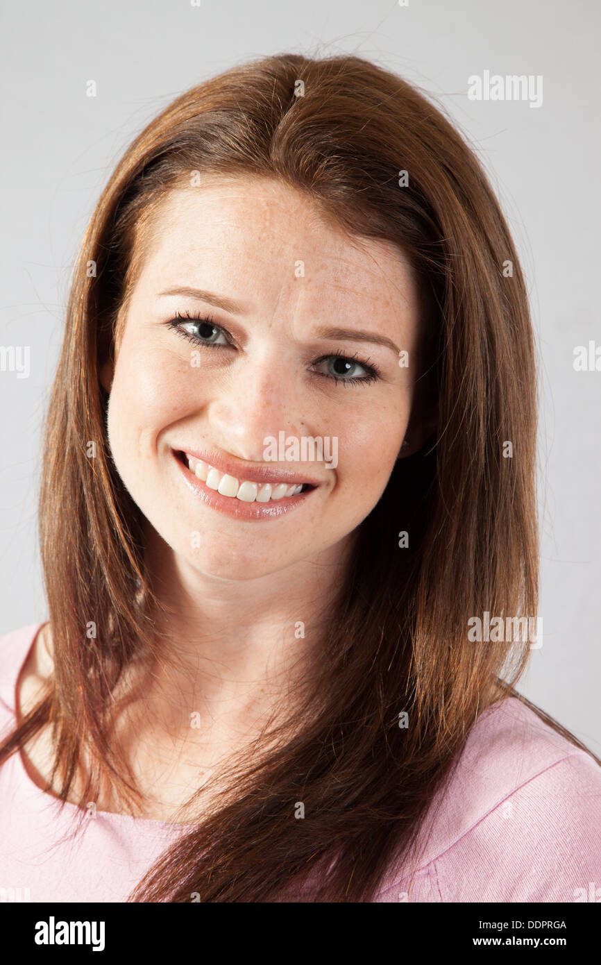 Pretty Caucasian girl in pink blouse, looking at the camera with a ...