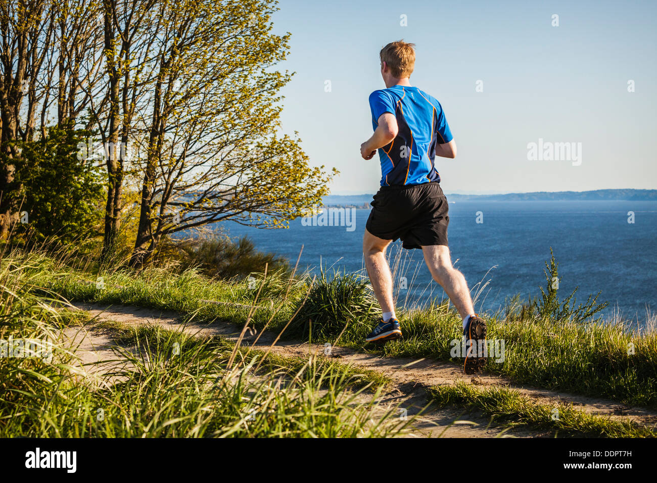 A young man running down stair steps on a trail in Discovery Park ...