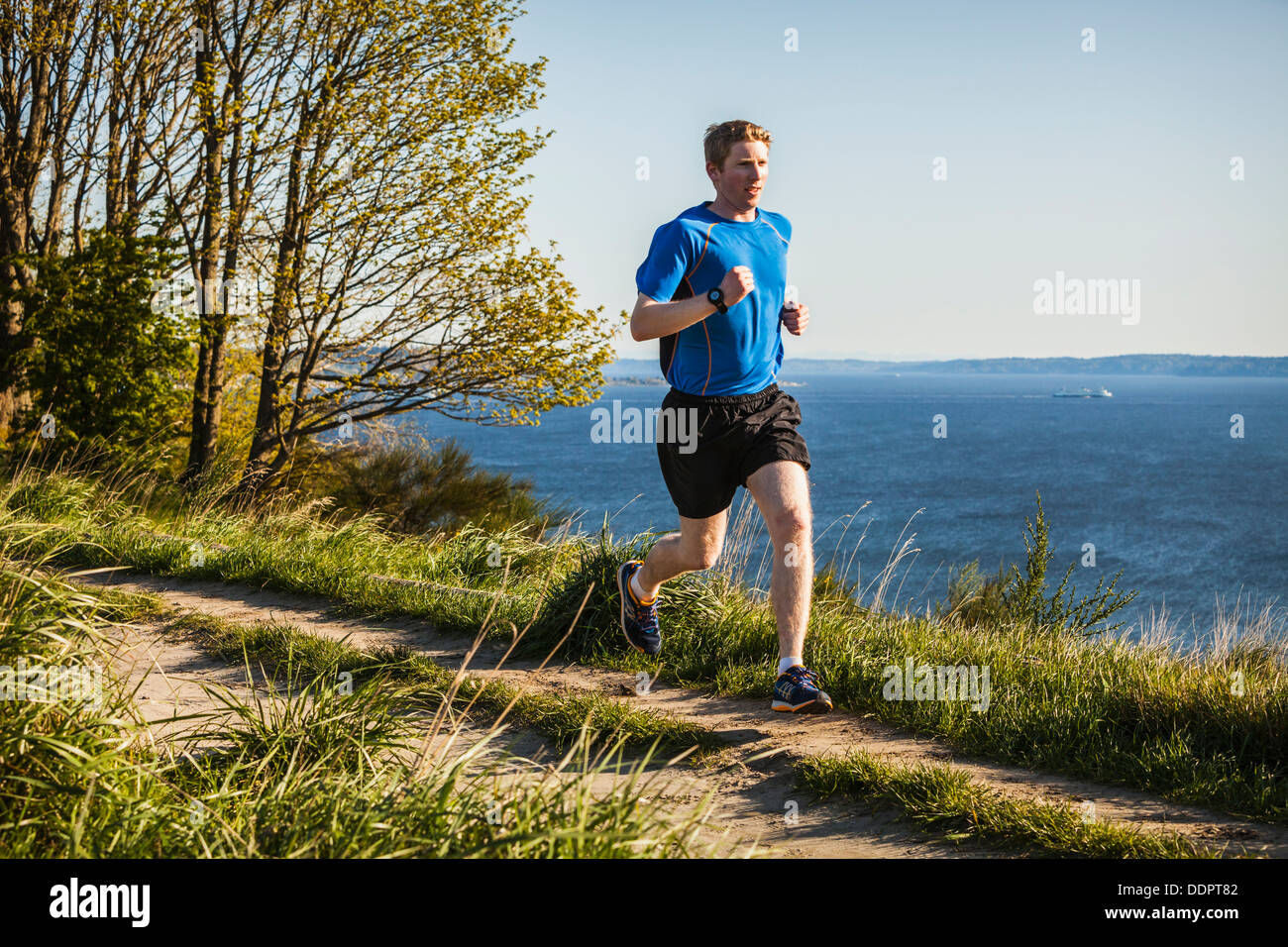 A young man running one of the trails in Seattle's Discovery Park ...