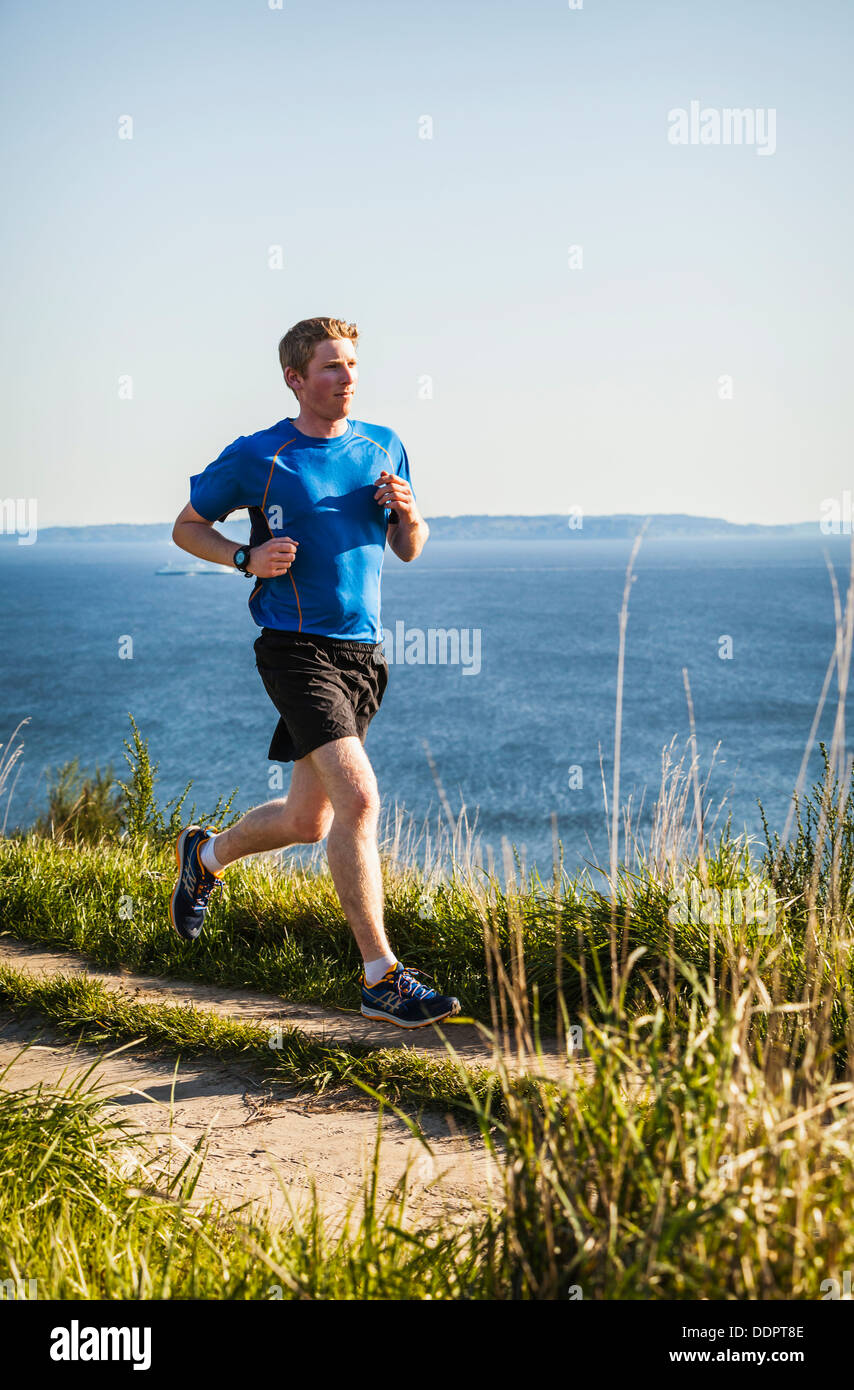 A young man running one of the trails in Seattle's Discovery Park ...