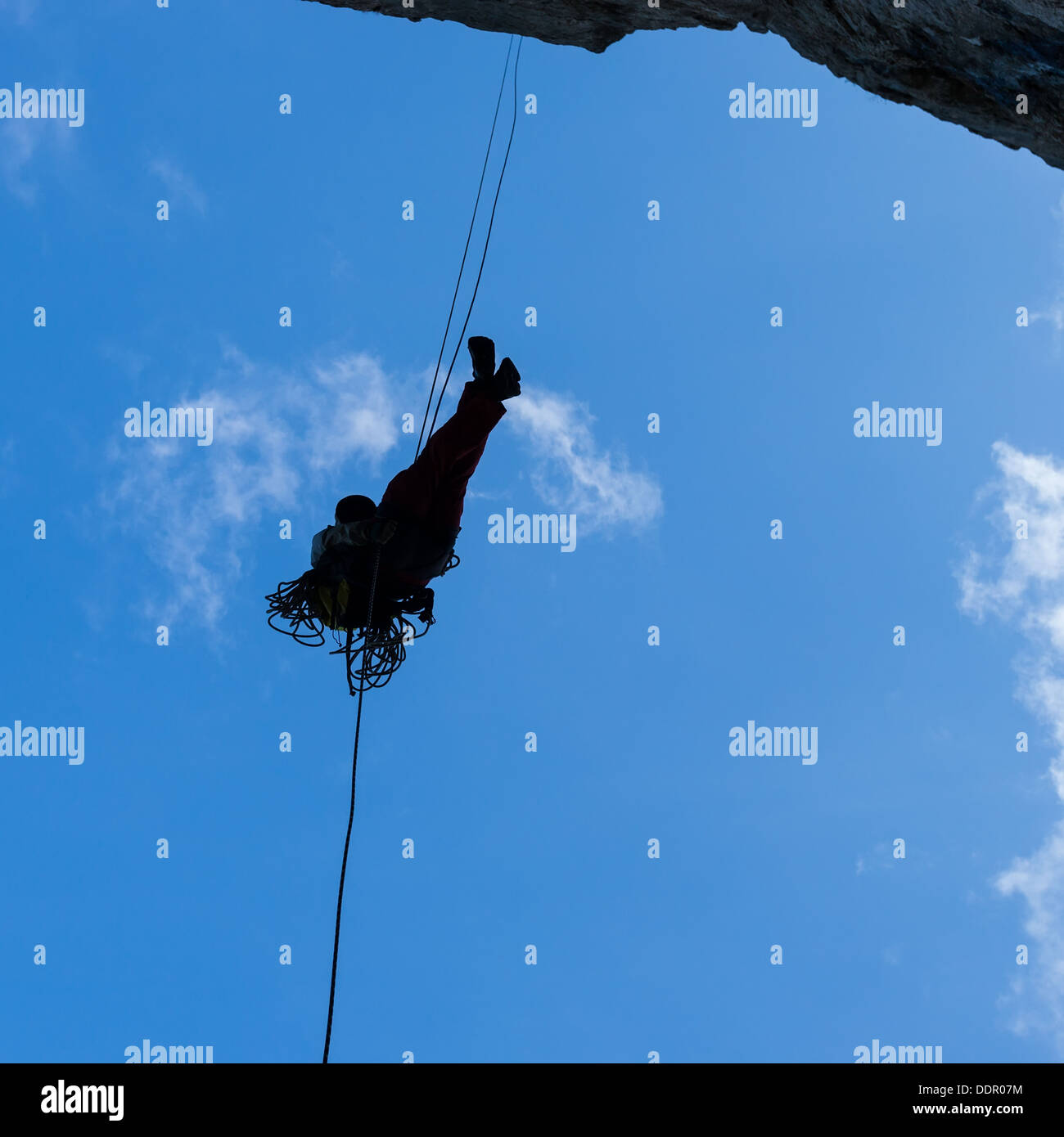 Silhouette of a rappelling man Stock Photo - Alamy