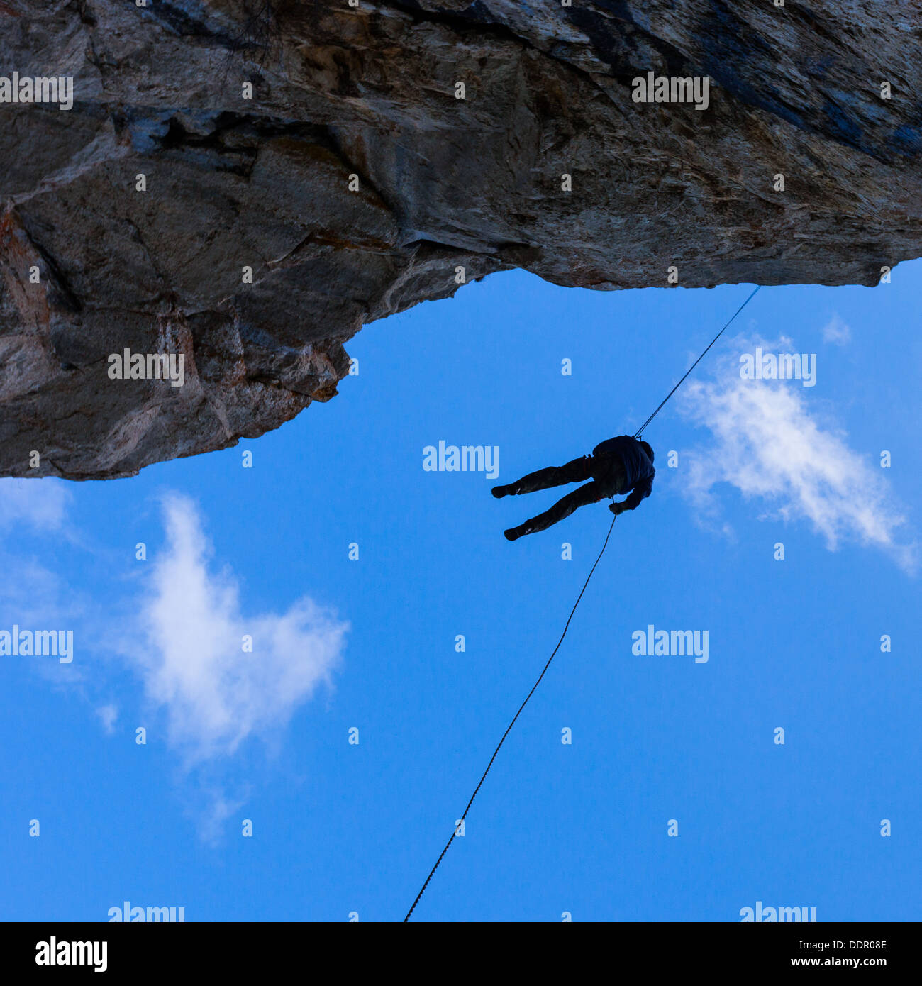Silhouette of a rappelling man Stock Photo - Alamy