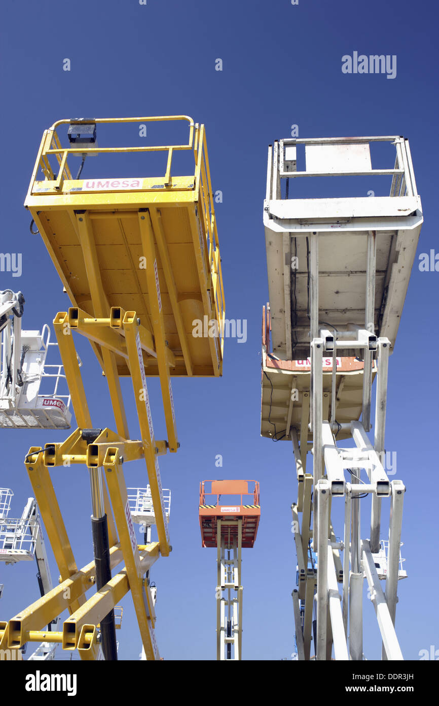 Several goose neck hoist parked on construction side streching their ...