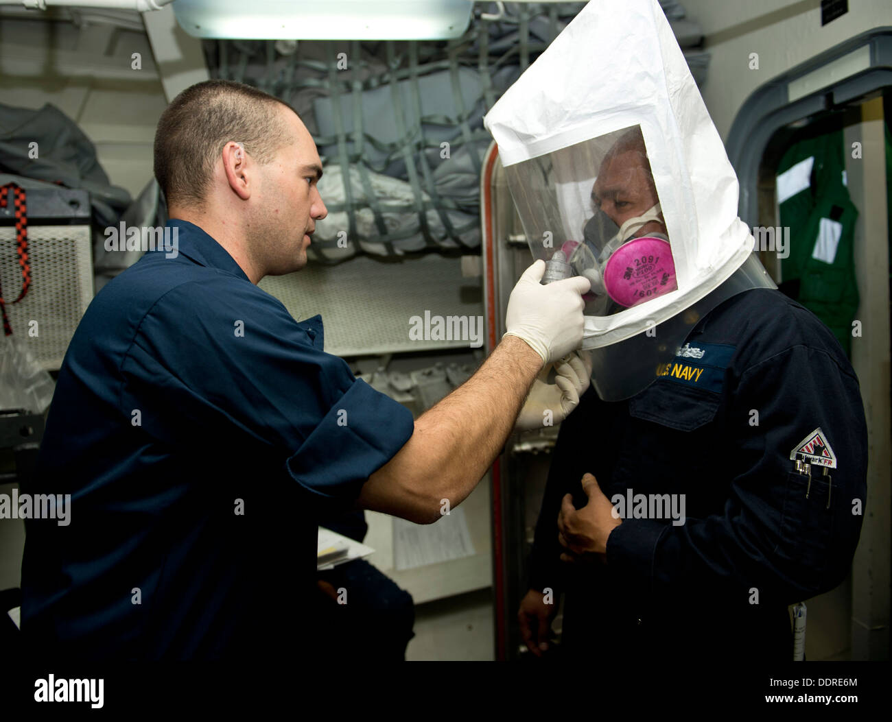 Quartermaster 1st Class Robert Persi, left, conducts a respirator fit ...