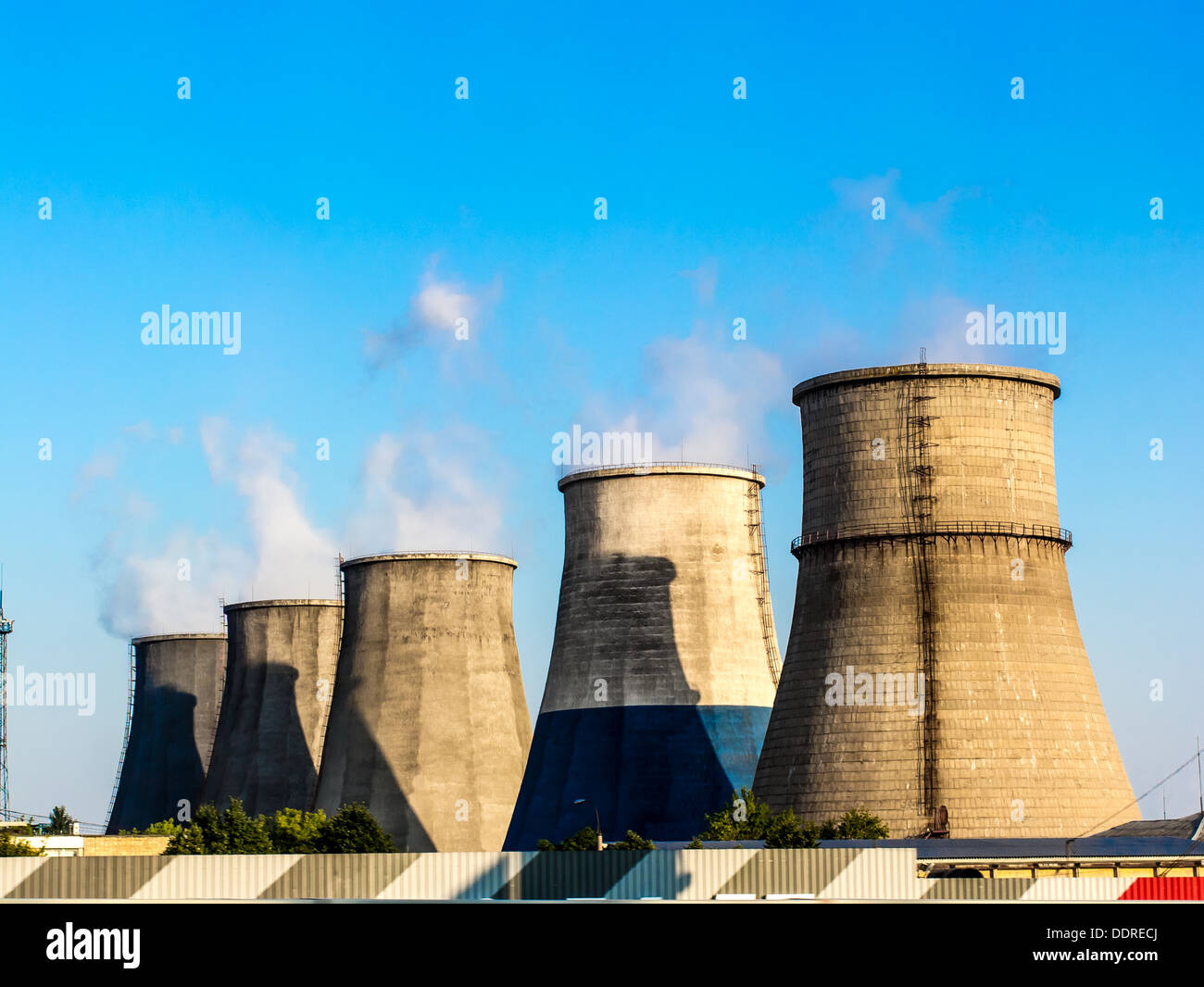 Big towers with white smoke and blue sky Stock Photo - Alamy