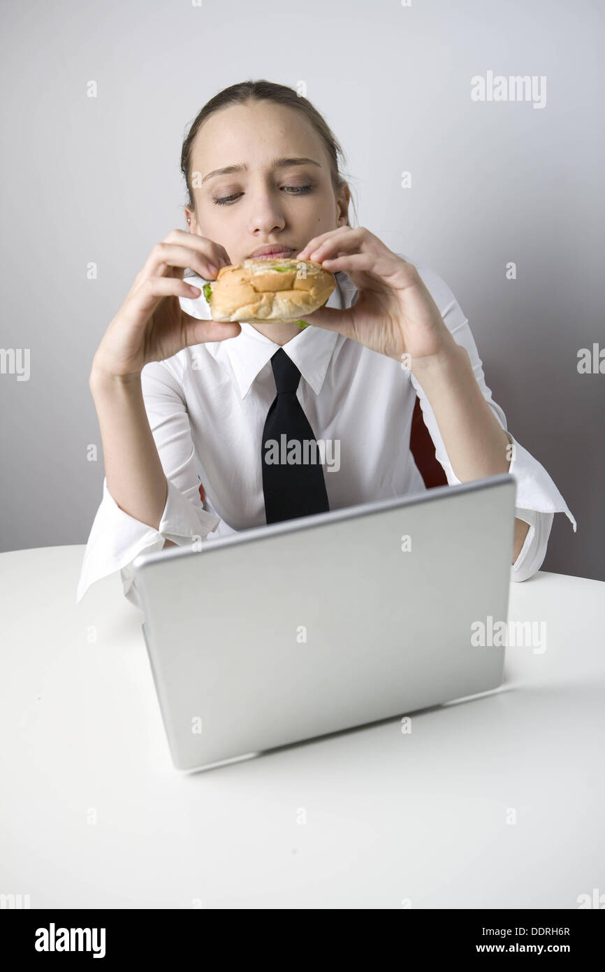 Business Woman Eating Sandwich and Working Stock Photo - Alamy