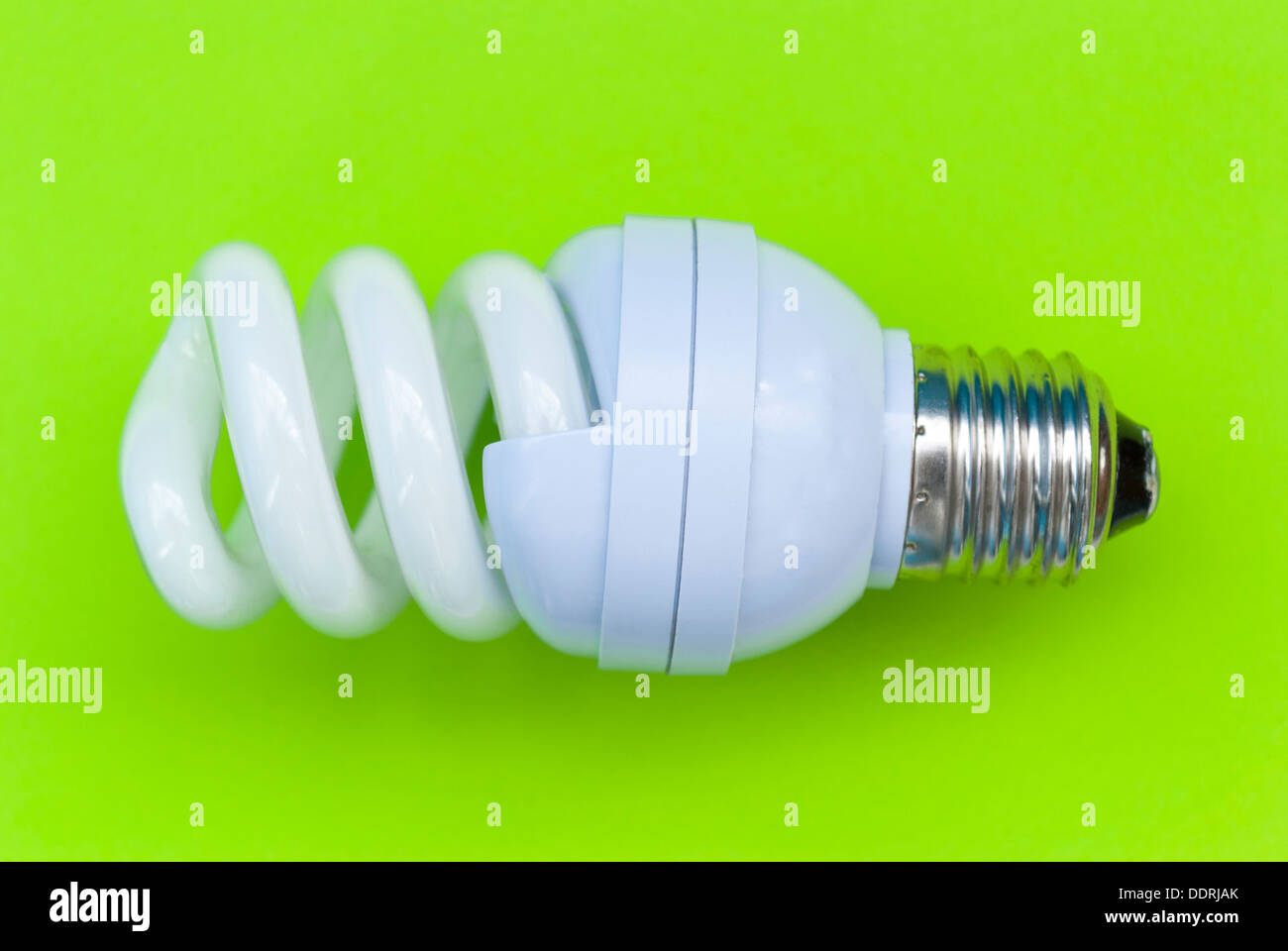 Energy saving bulb on a green background Stock Photo - Alamy