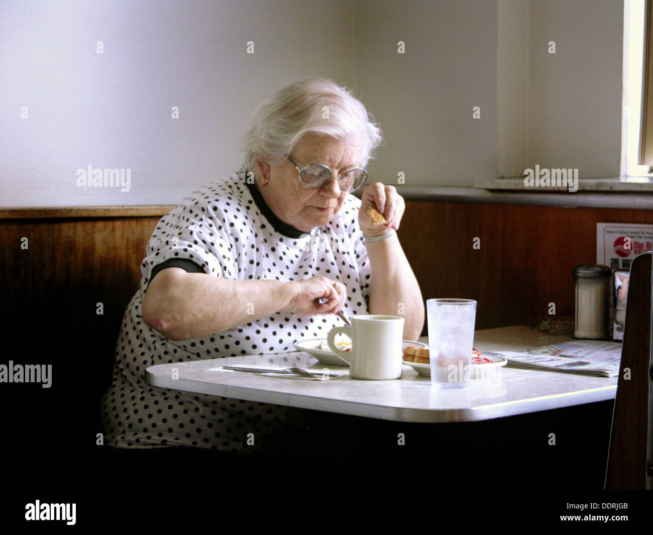 Senior woman eating breakfast alone hi-res stock photography and images ...