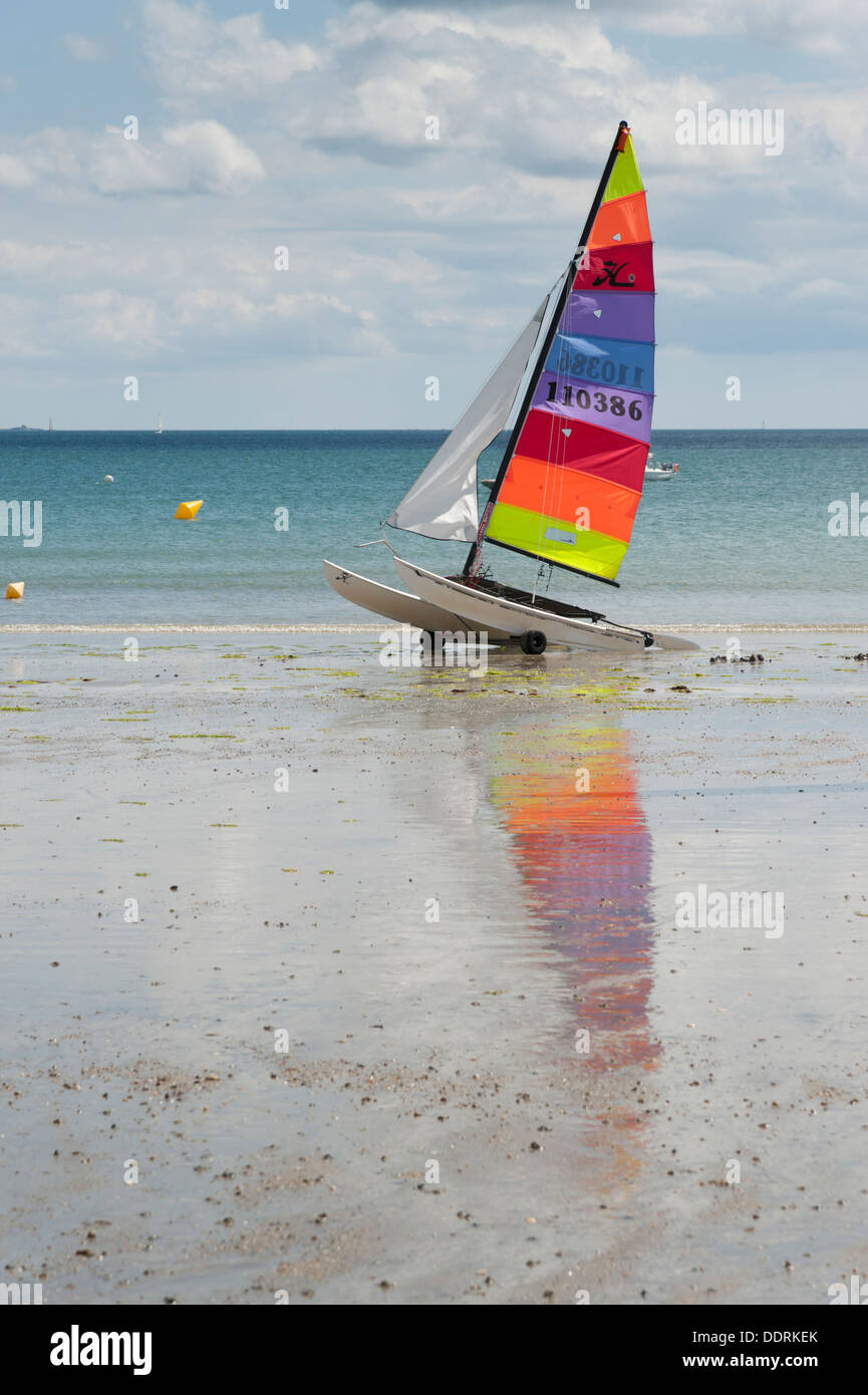 Colourful sailing dingy on the beach at Cap Coz Brittany France with ...