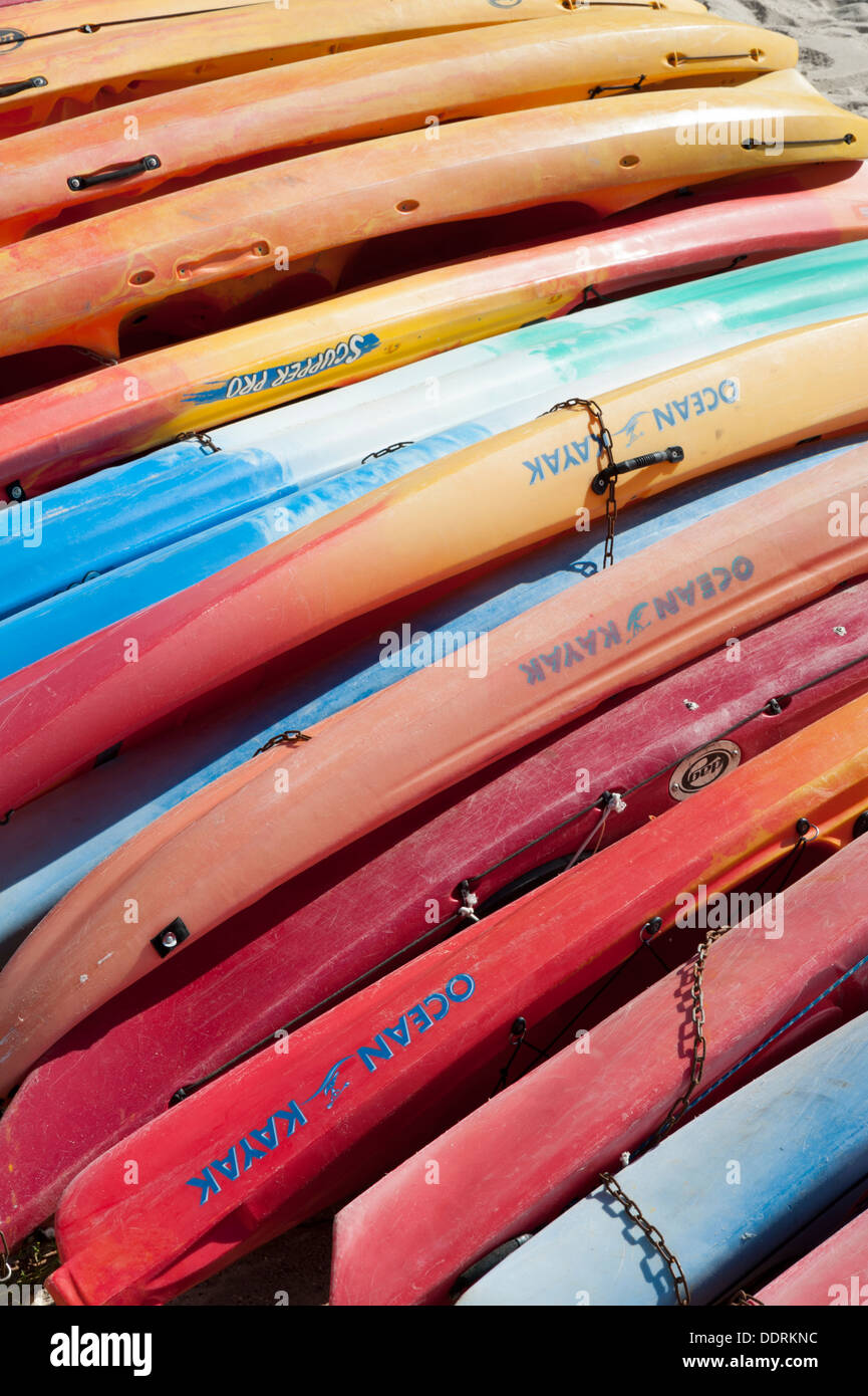 Ocean kayaks stacked together on a beach forming interesting and ...