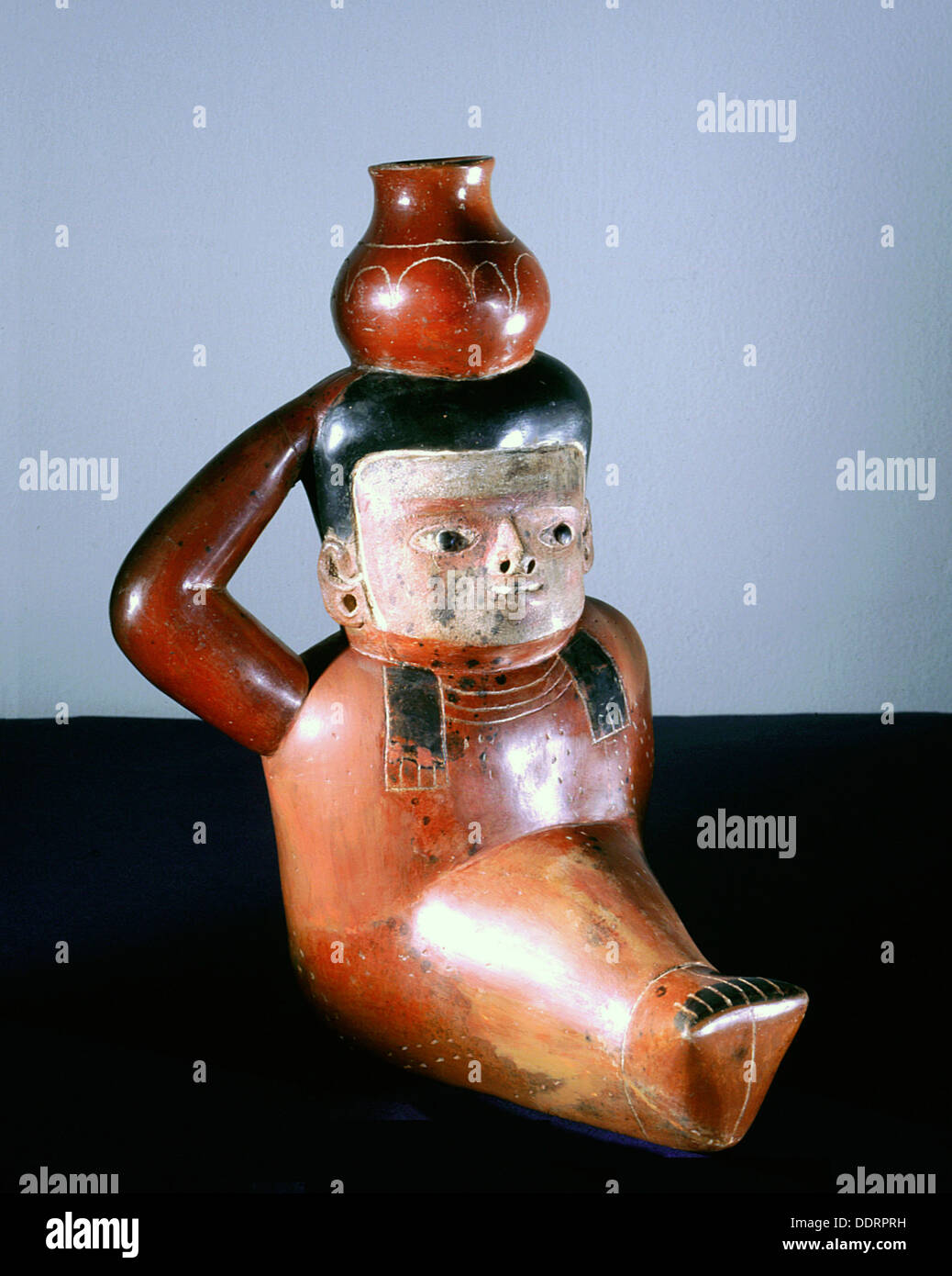 Chavin polychrome ceramic jug in the form of a seated figure carrying a ...