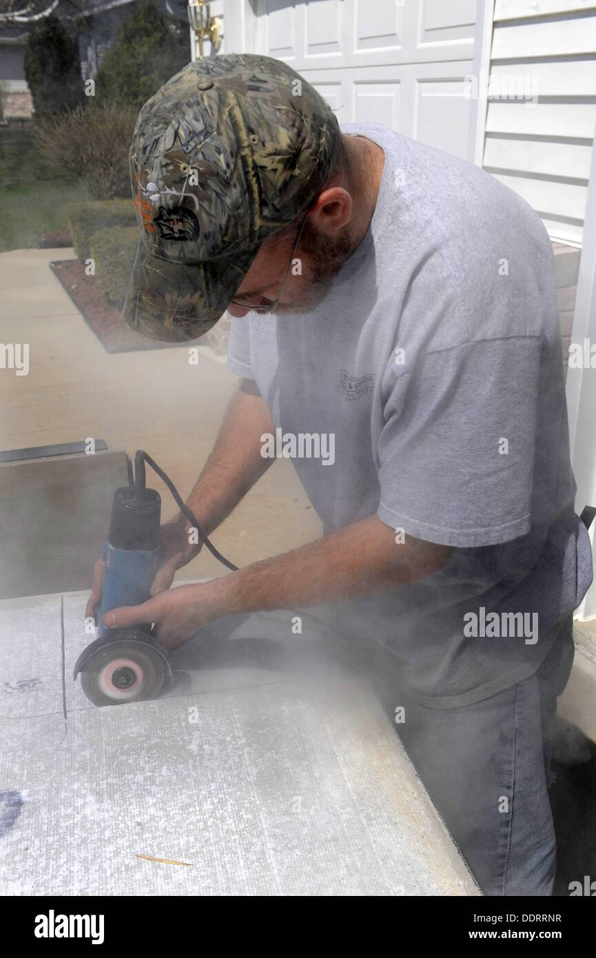 Carpenter using power cutting tool in construction project Stock Photo ...