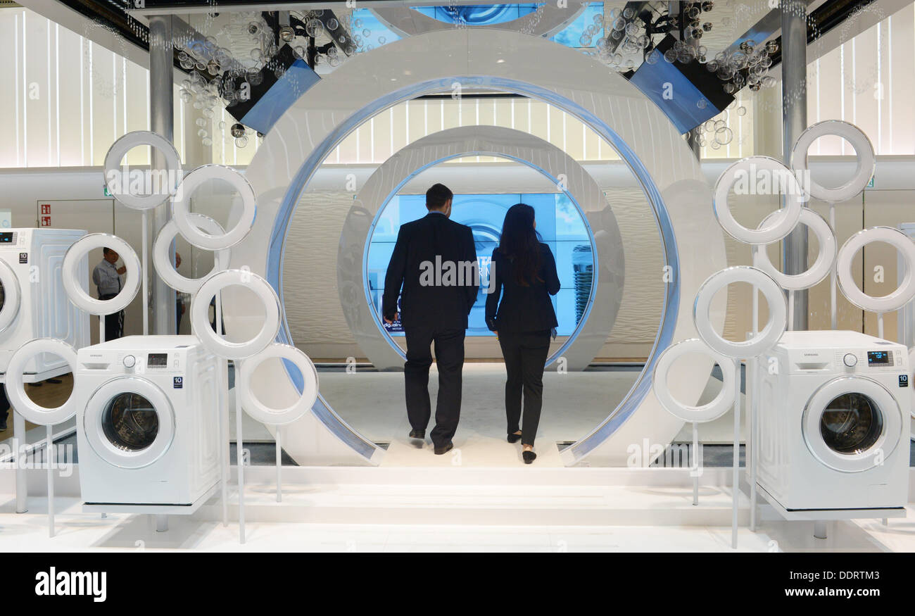 Two people walk through an installation with washing machines at the ...