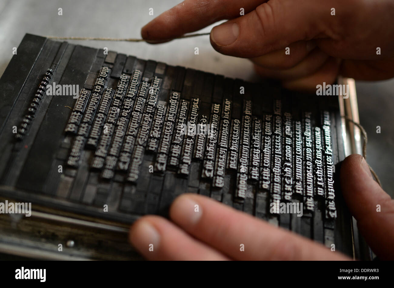 A typesetter of the Museum für Druckkunst Leipzig binds lead letters ...