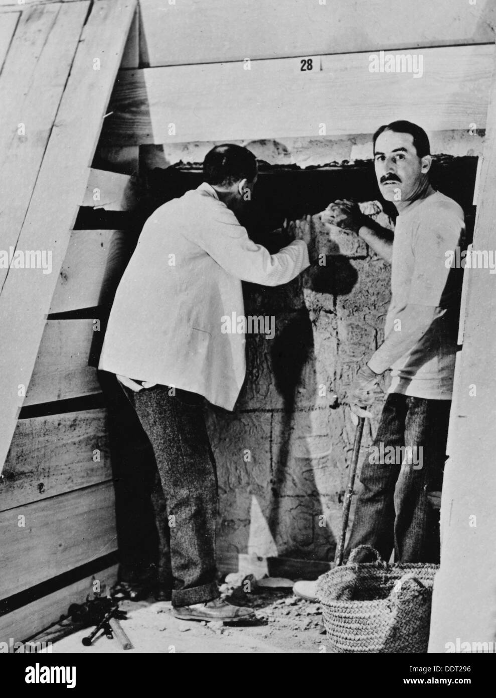 Howard Carter and a colleague excavating a tomb in the Valley of the ...