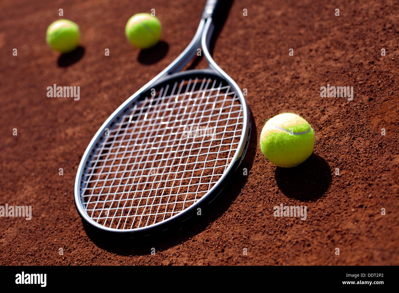 Tennis balls and rocket on court field in sunny day Stock Photo - Alamy