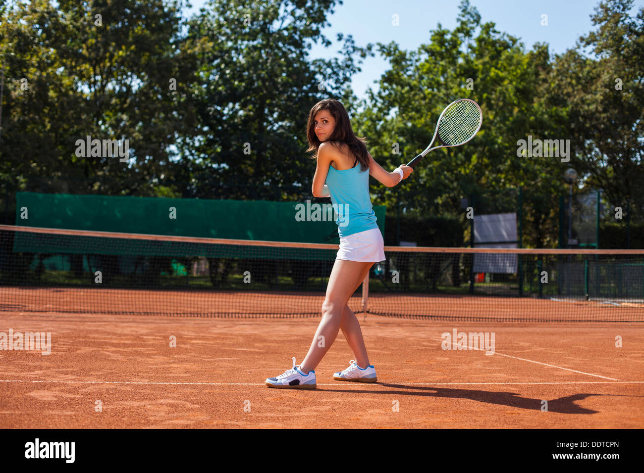 Pretty girl playing in tennis on court Stock Photo - Alamy