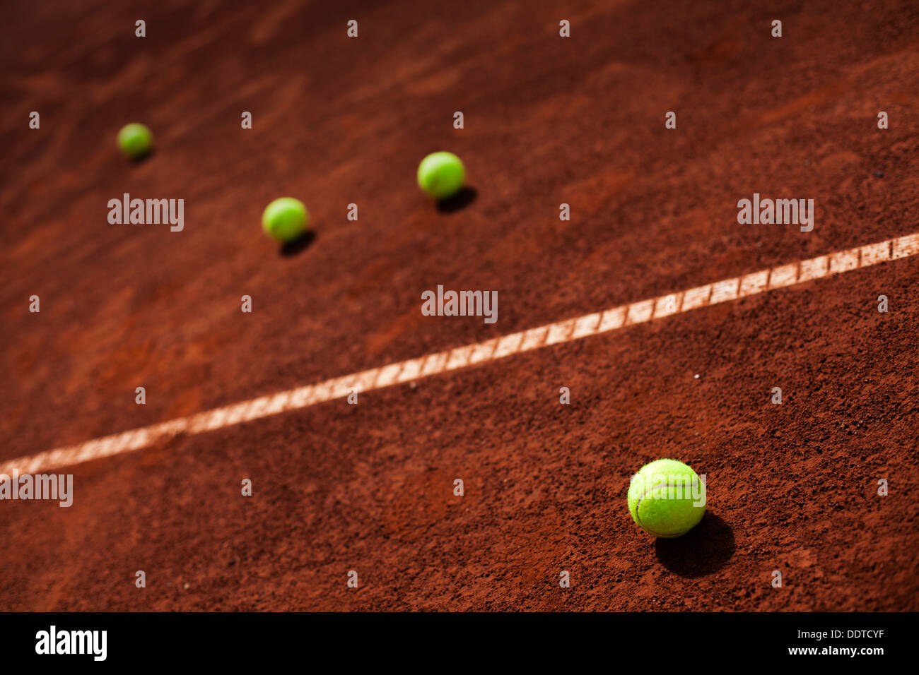Tennis balls and rocket on court field in sunny day Stock Photo - Alamy