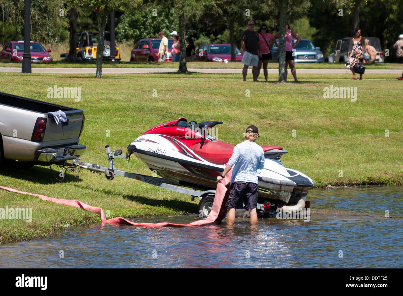 Man launching a jet ski into a lake Stock Photo - Alamy