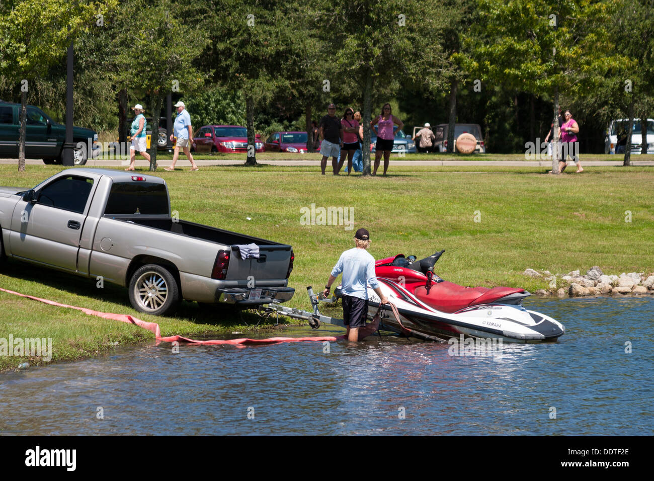 Man launching a jet ski into a lake Stock Photo - Alamy