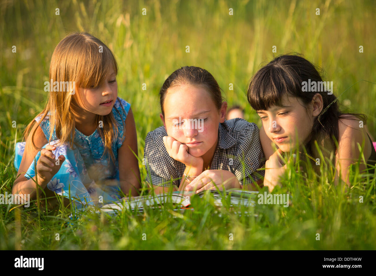 Three girls reading together hi-res stock photography and images - Alamy