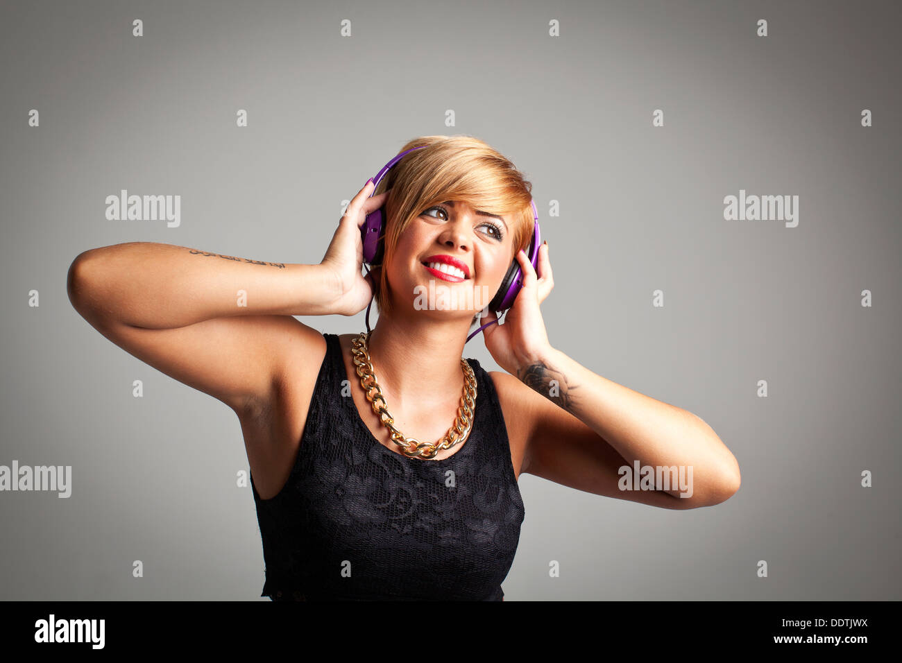 Pretty Female Model smiling listening to music Stock Photo - Alamy