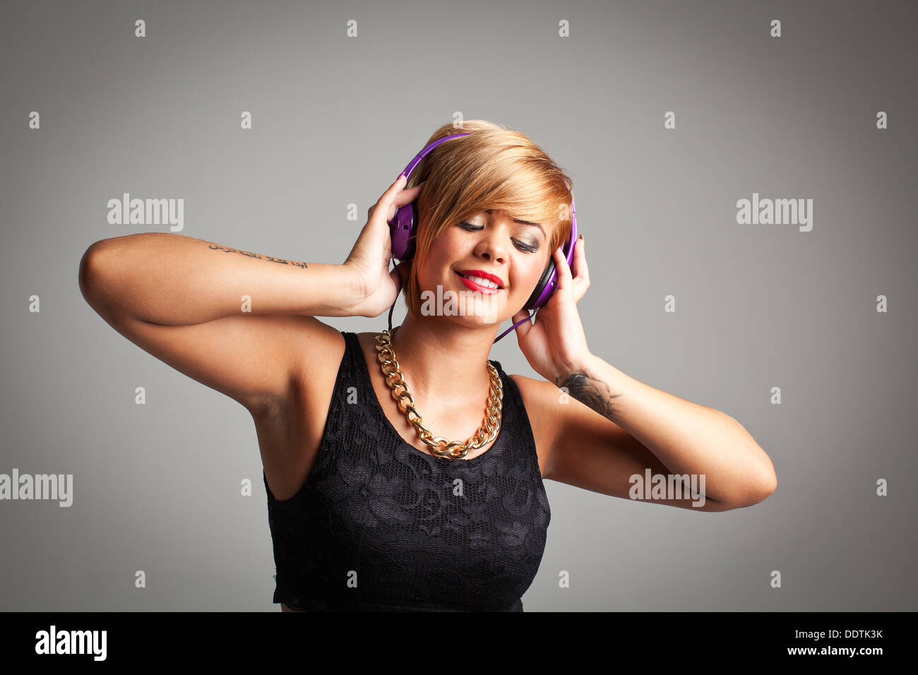 Pretty Female Model listening to music Stock Photo - Alamy