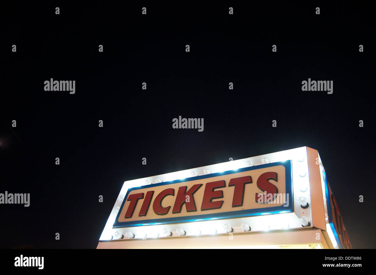 Tickets sign lit up at night with red lettering blue border and lights ...