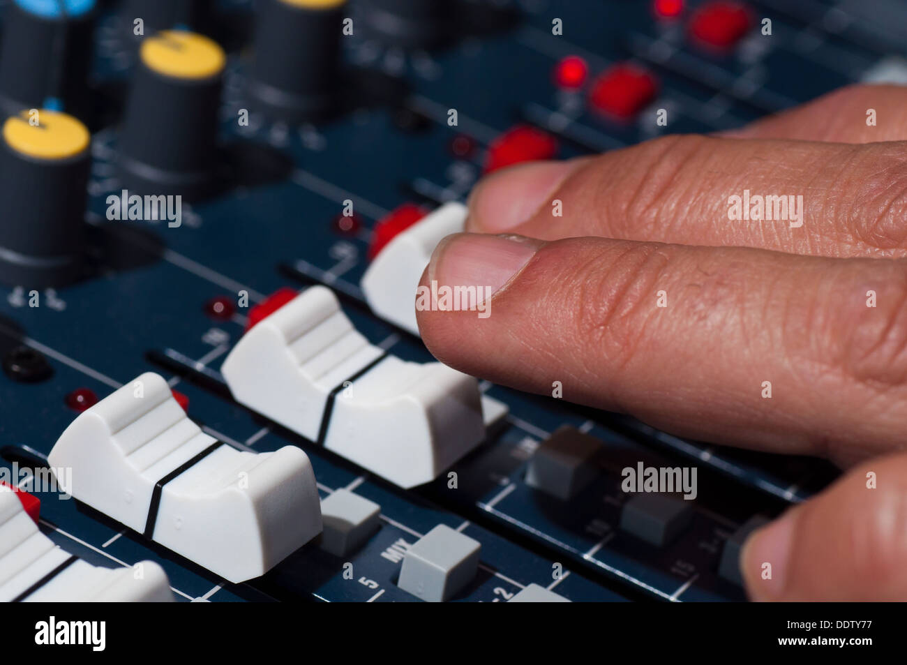 Sound engineer's hand moving sliders on audio mixing board Stock Photo ...