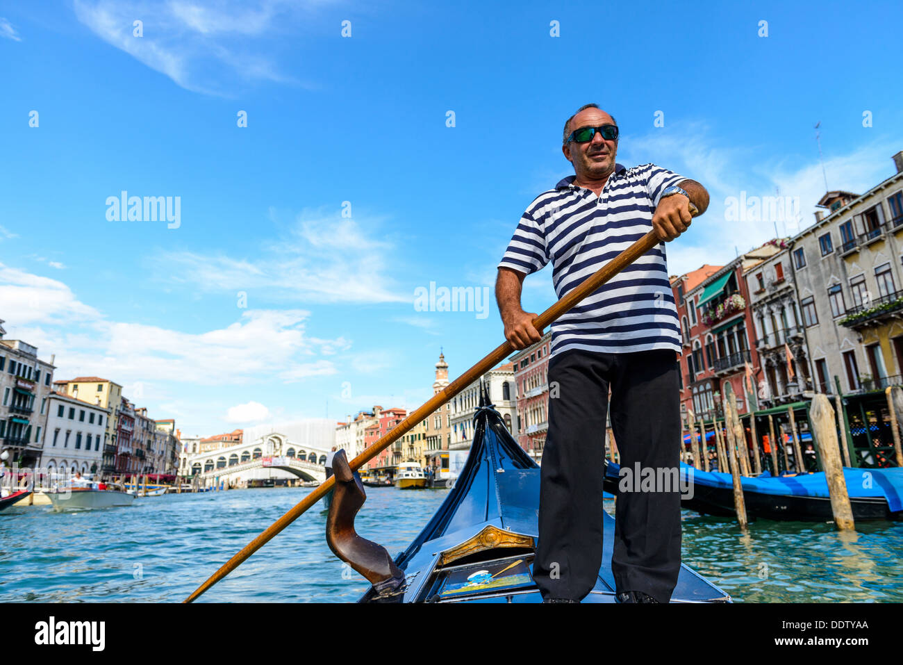 A Gondolier in traditional outfit steers his Gondola along the Grand ...
