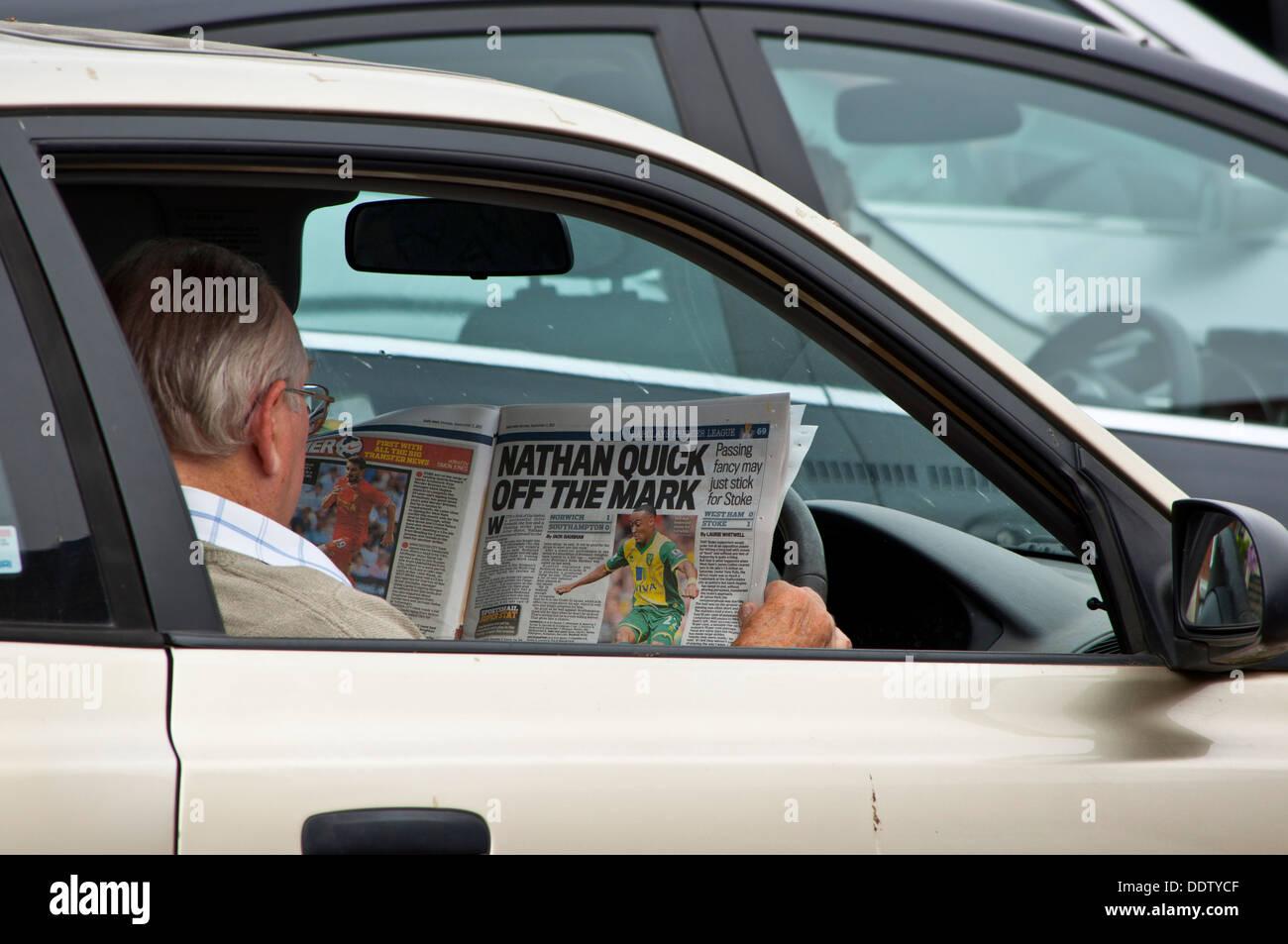 male pensioner reading newspaper in car Stock Photo - Alamy