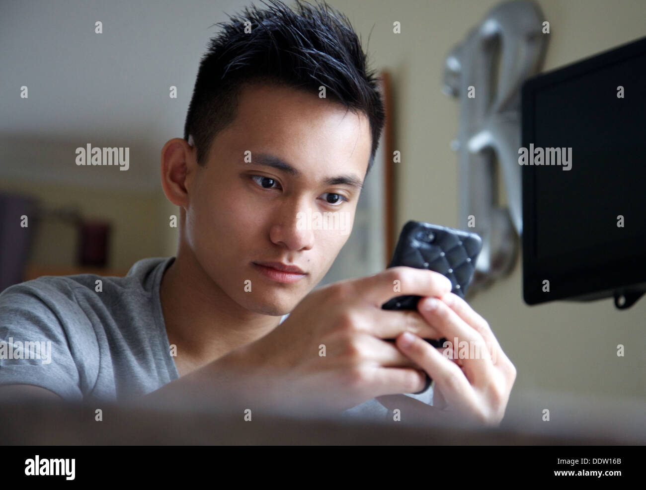 A young guy texting on his mobile phone, England Stock Photo - Alamy