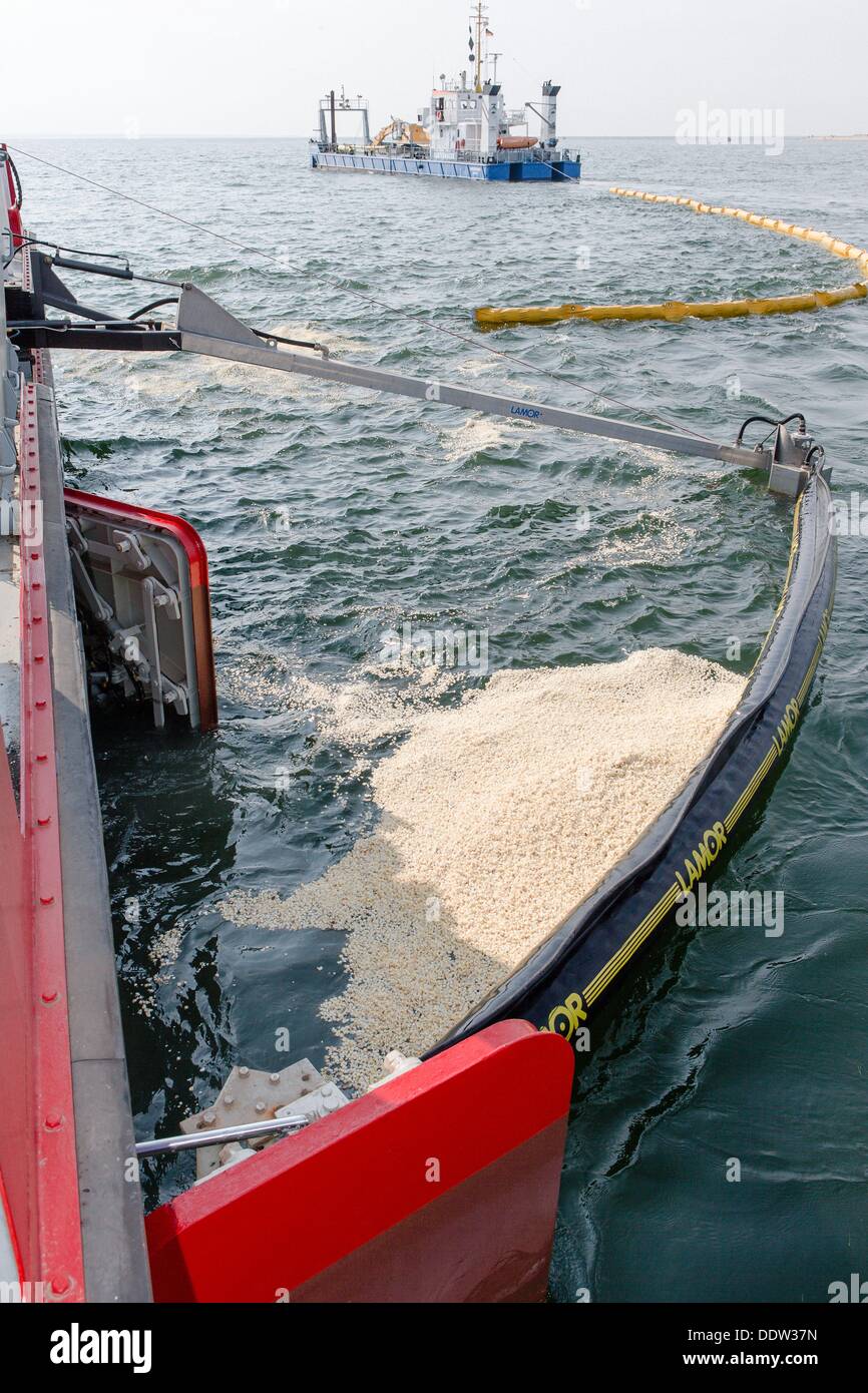 Two oil recovery vessels sail during an exercise with a funnel through ...