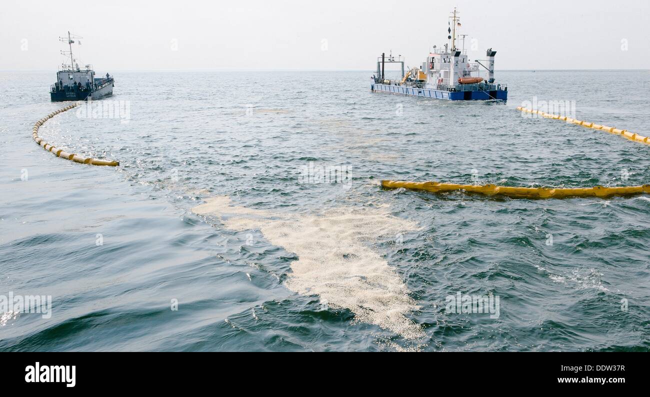 Two oil recovery vessels sail during an exercise with a funnel through ...