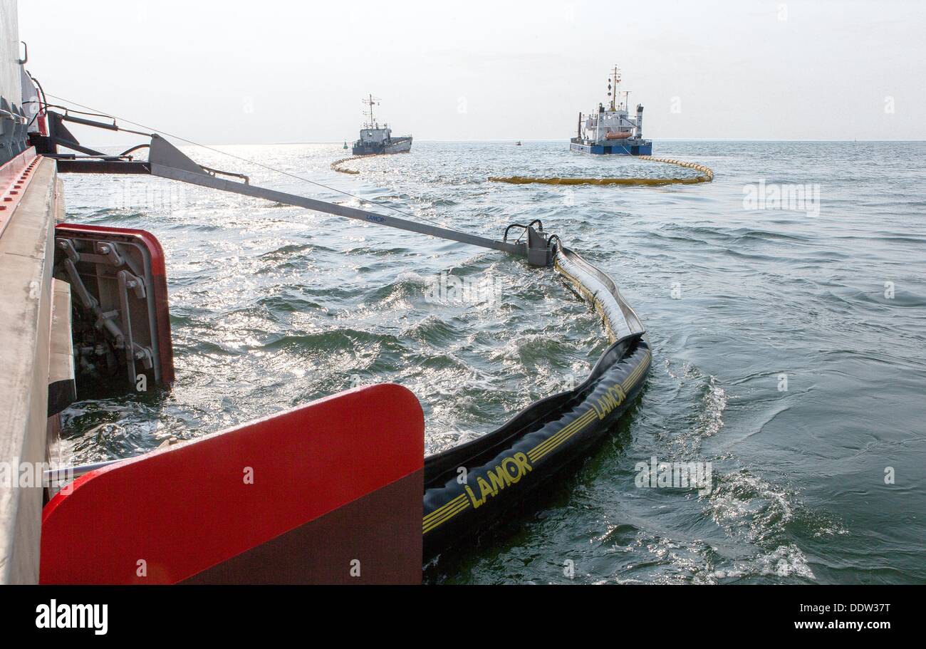 Two oil recovery vessels sail during an exercise with a funnel through ...