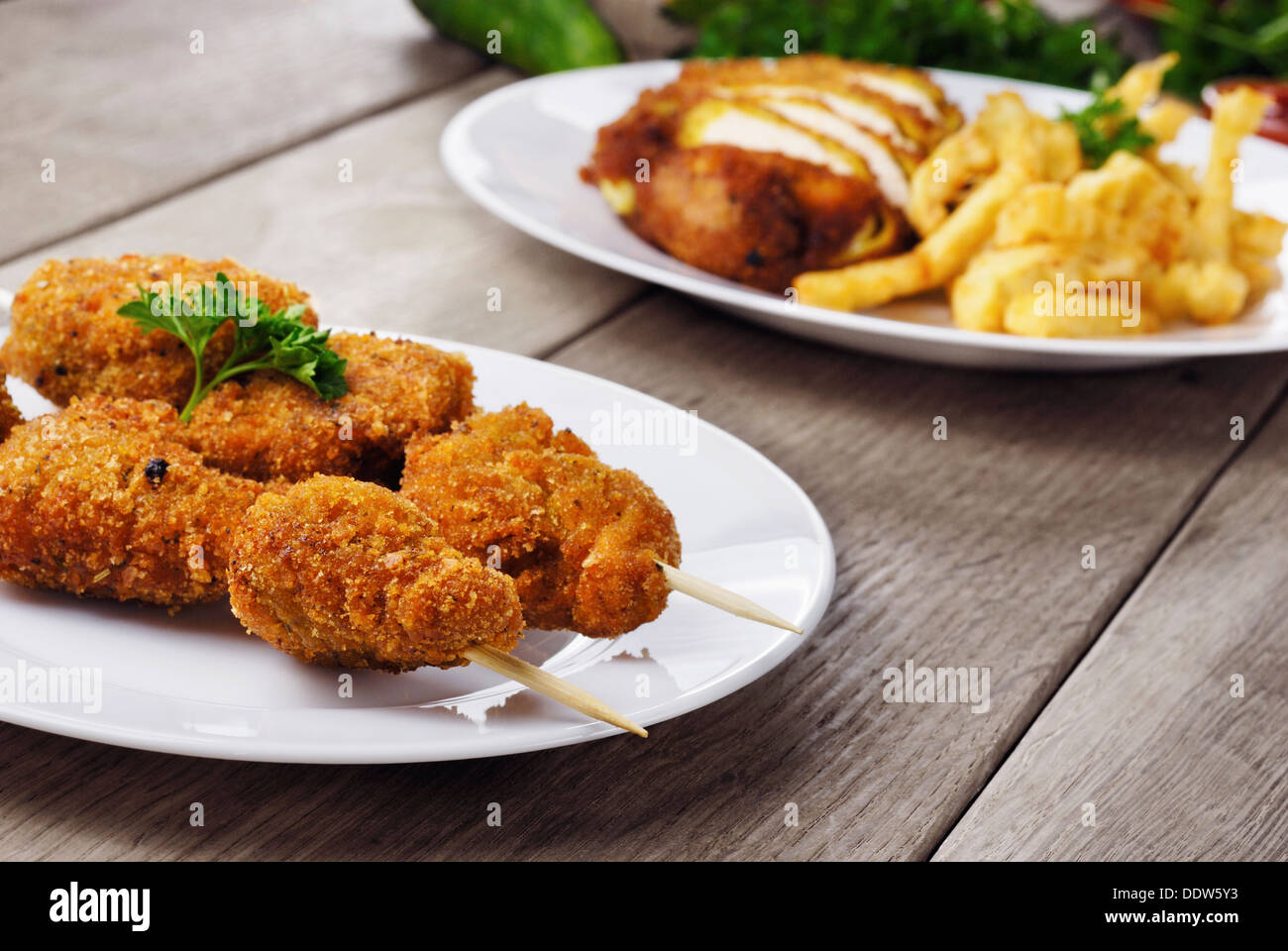 Tasty fried chicken kebab on the white plate on the wooden table Stock ...