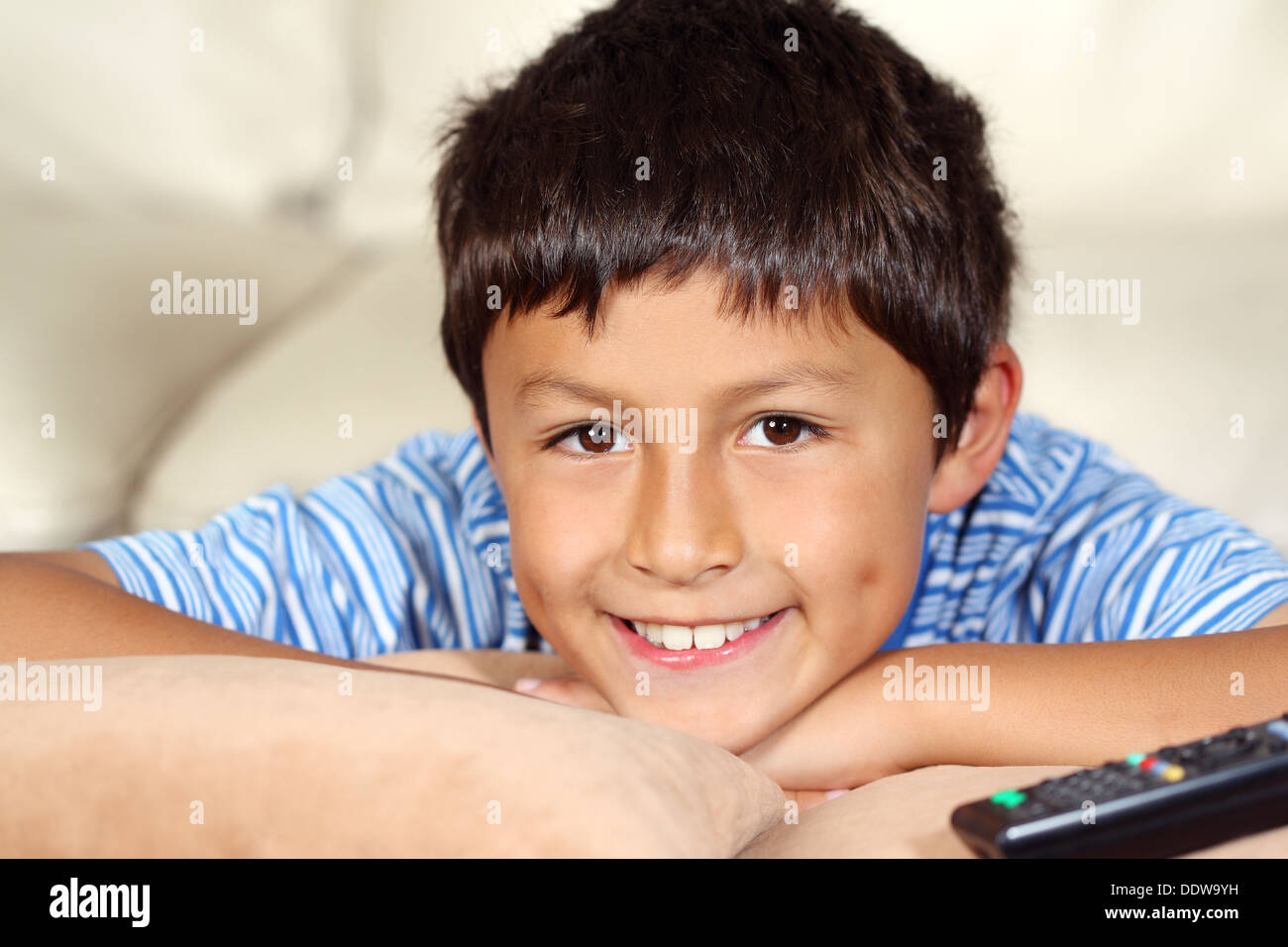 Young boy watching TV with remote control Stock Photo - Alamy