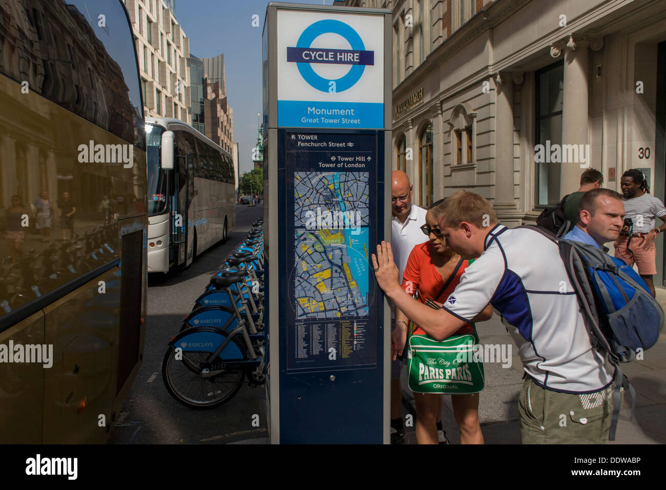 Tourists look at a London map and information about renting a TFL ...