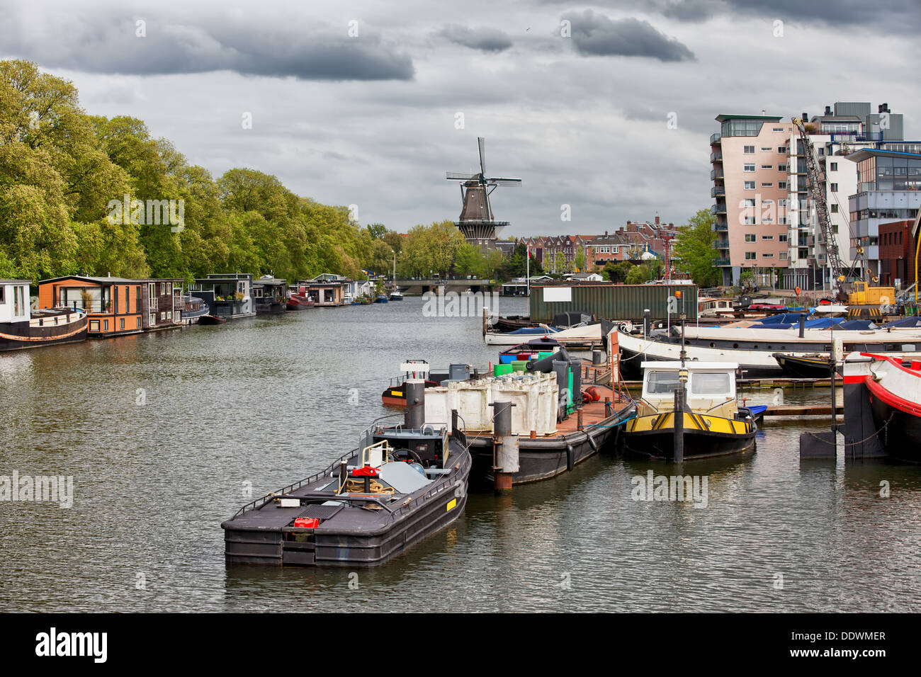 Boats on Nieuwevaart Canal with De Gooyer Windmill on the horizon in ...