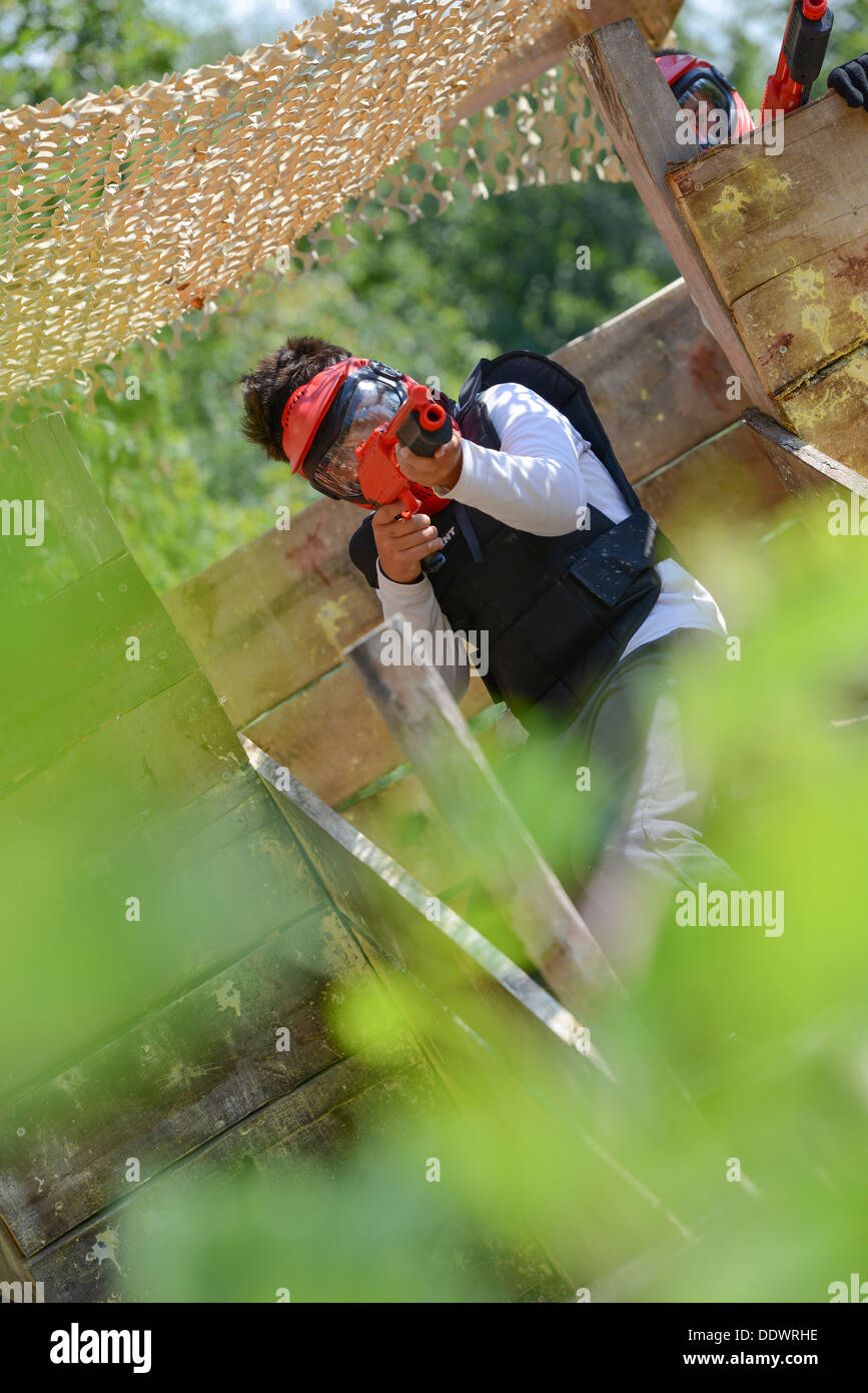 Young children playing paintball in the woods Stock Photo - Alamy