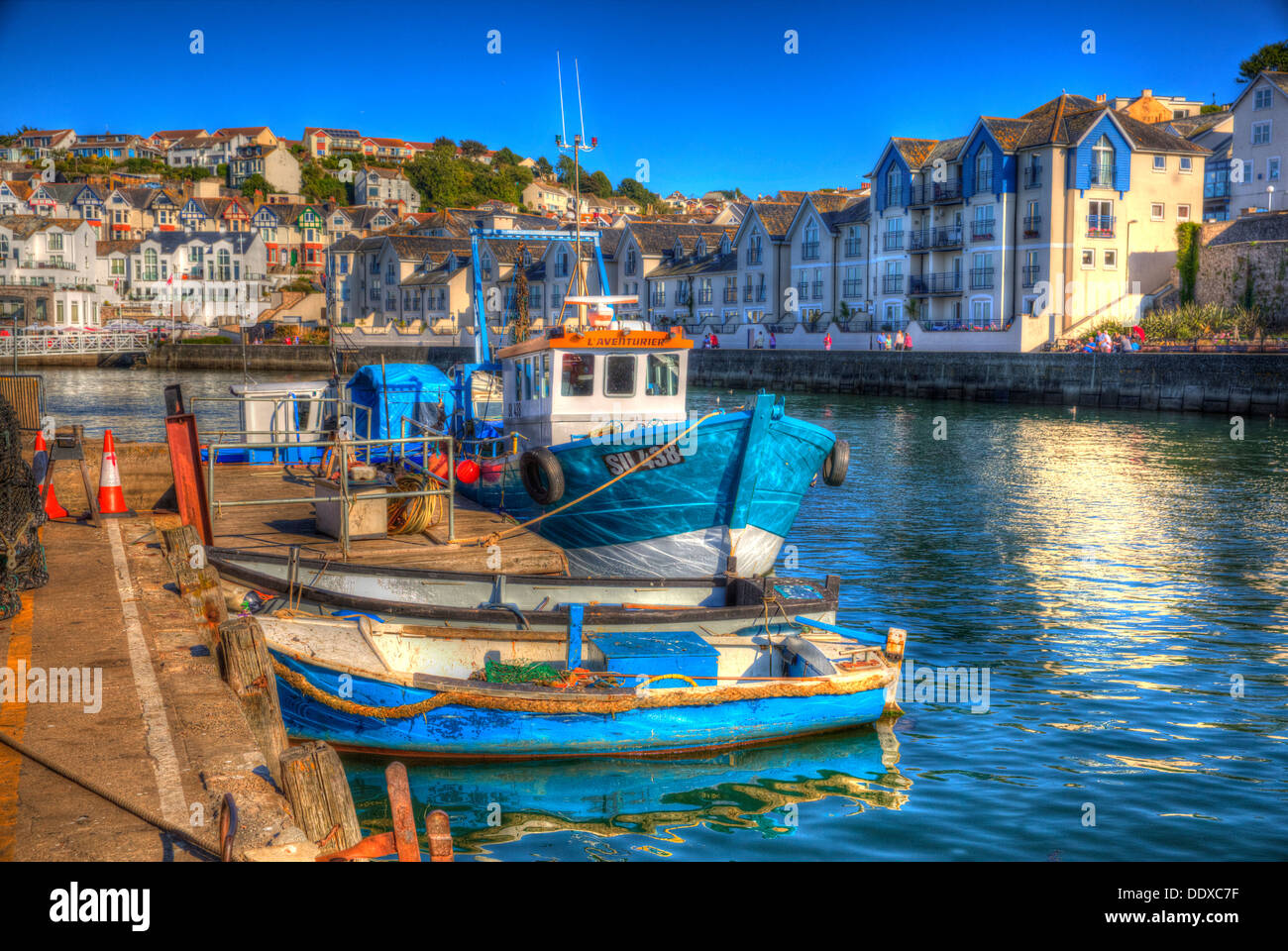 Blue fishing boats moored Brixham harbor Devon with vivid blue sky and ...