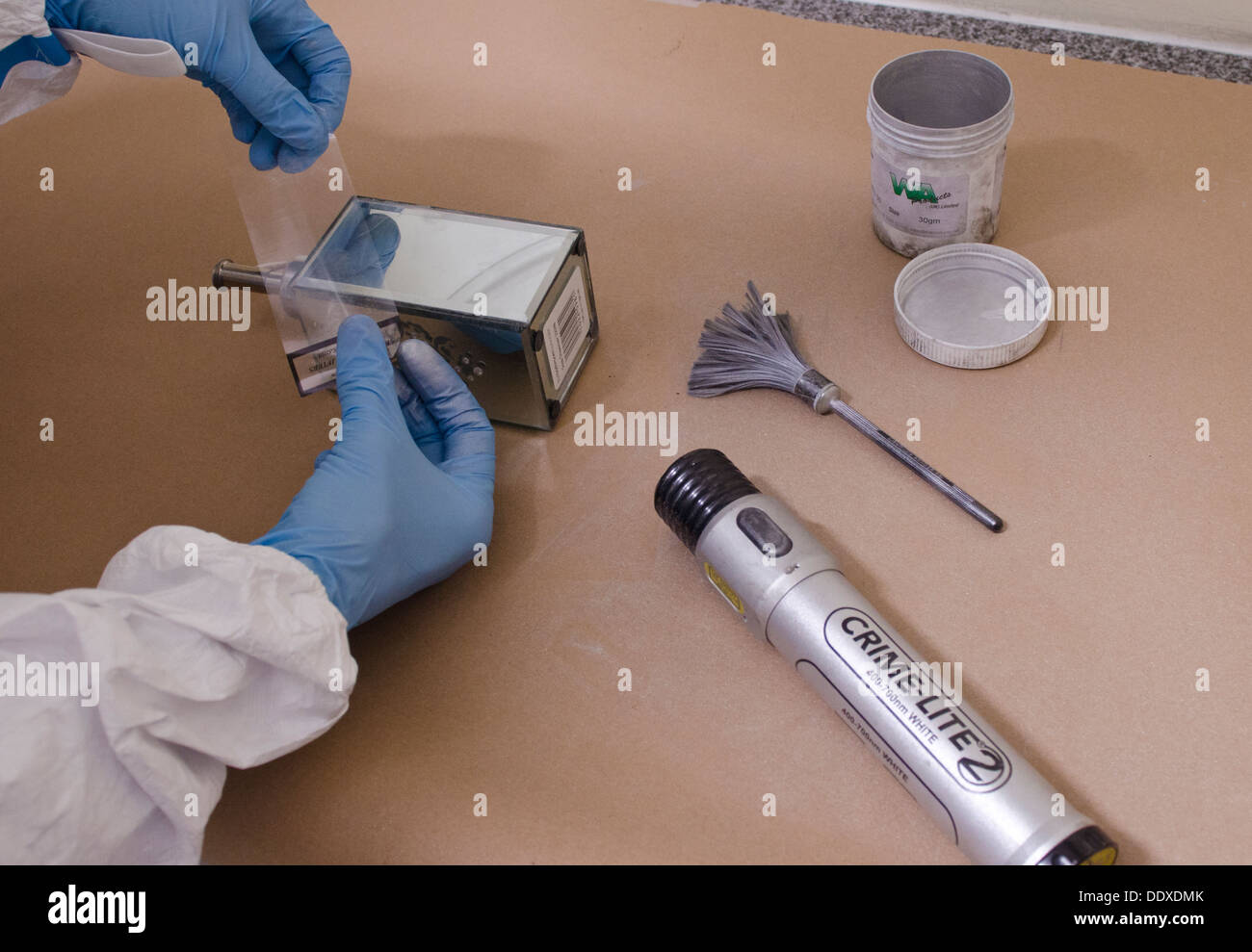 A CSI (Crime Scene Investigator) lifting off a fingerprint on a surface ...
