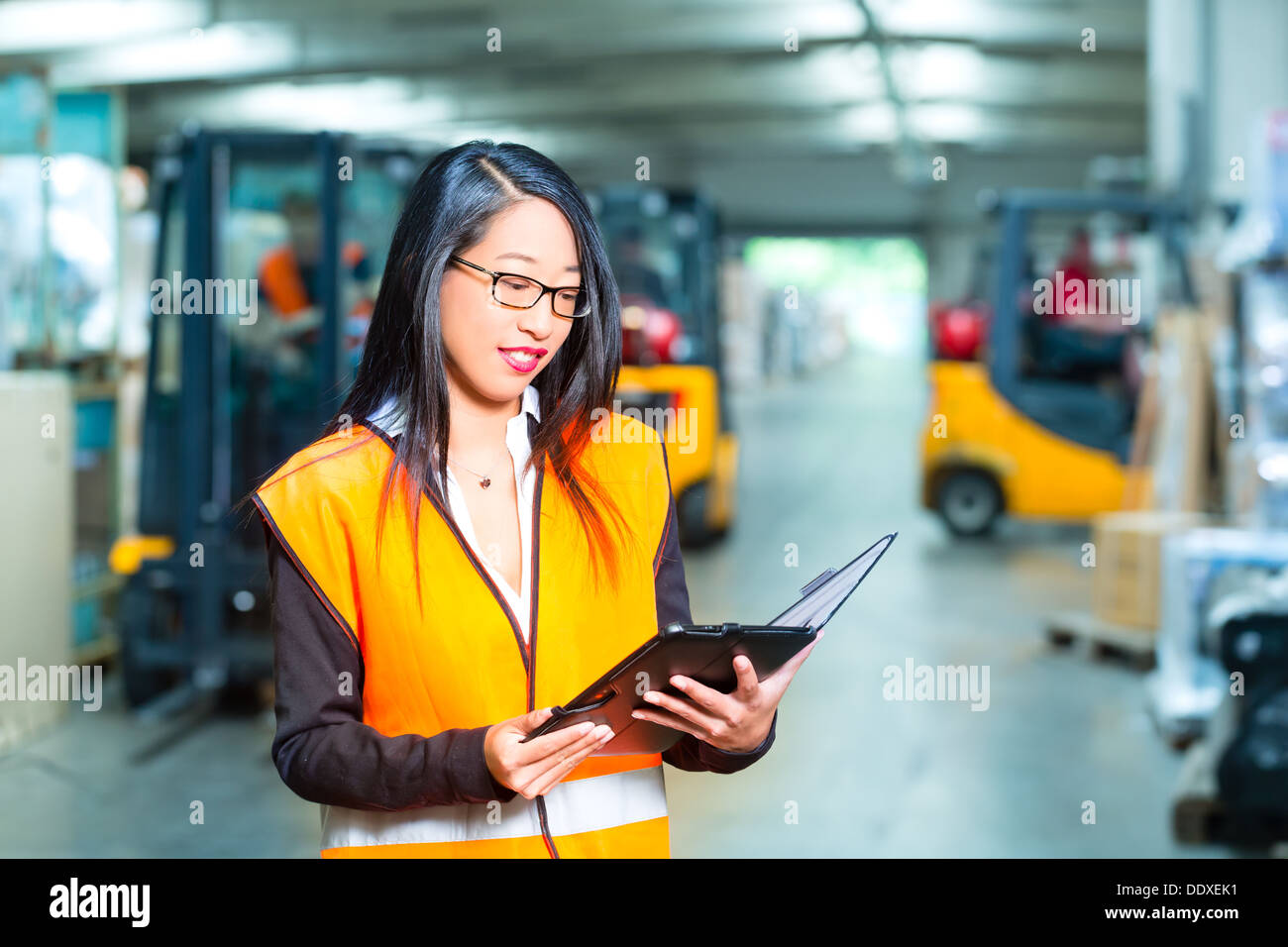 Logistics - female worker or supervisor using tablet computer at ...