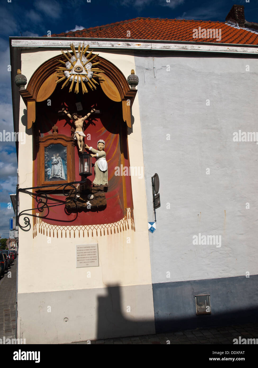 Bruges street house with Christ in the Cross representation on the wall ...